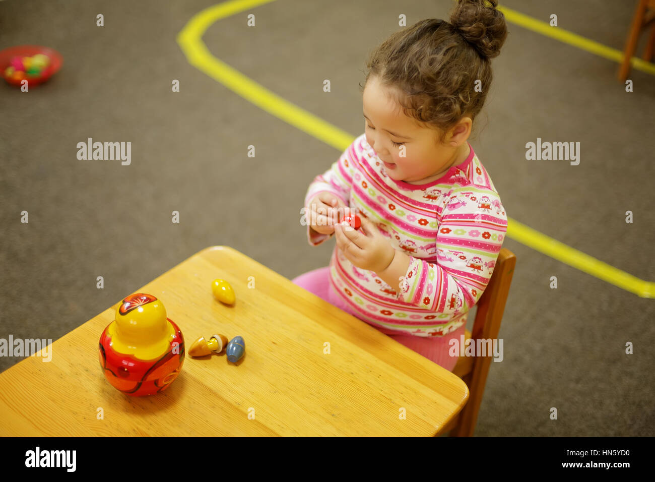 kazakh curly girl playing in kids development center Stock Photo - Alamy