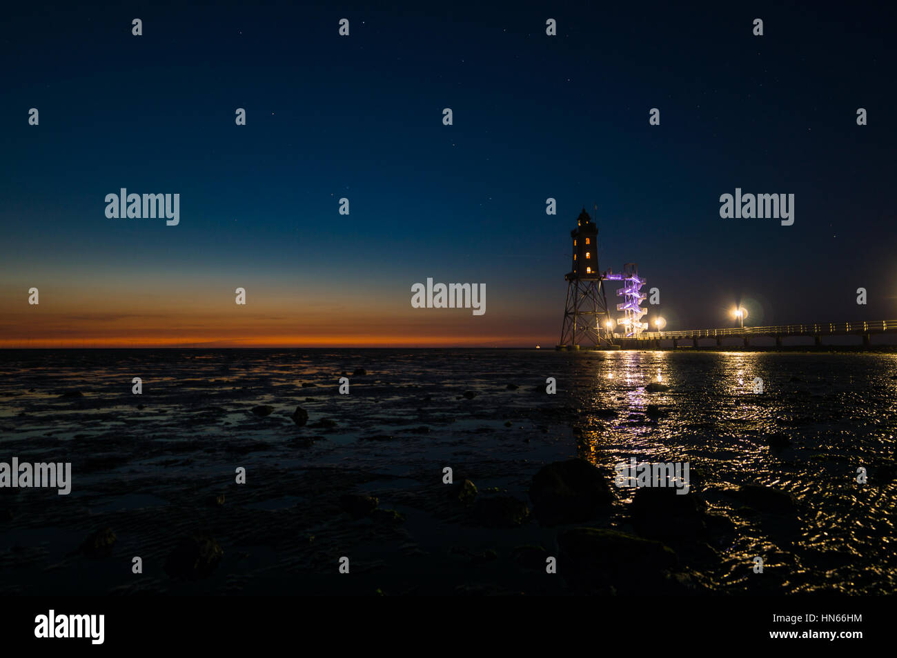 Wadden sea at night with lighthouse Stock Photo - Alamy
