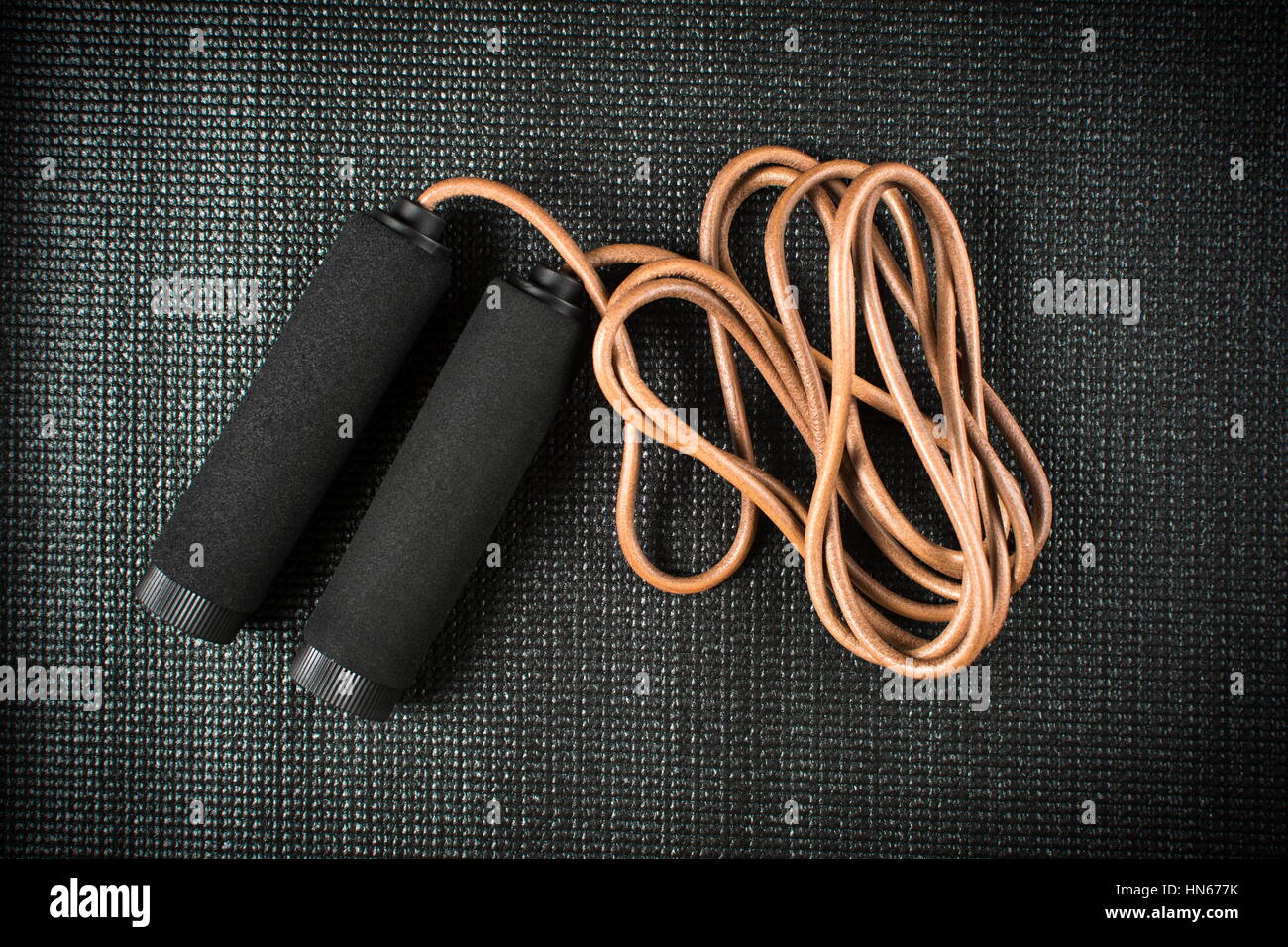 Leather jumping rope on black yoga mat Stock Photo - Alamy
