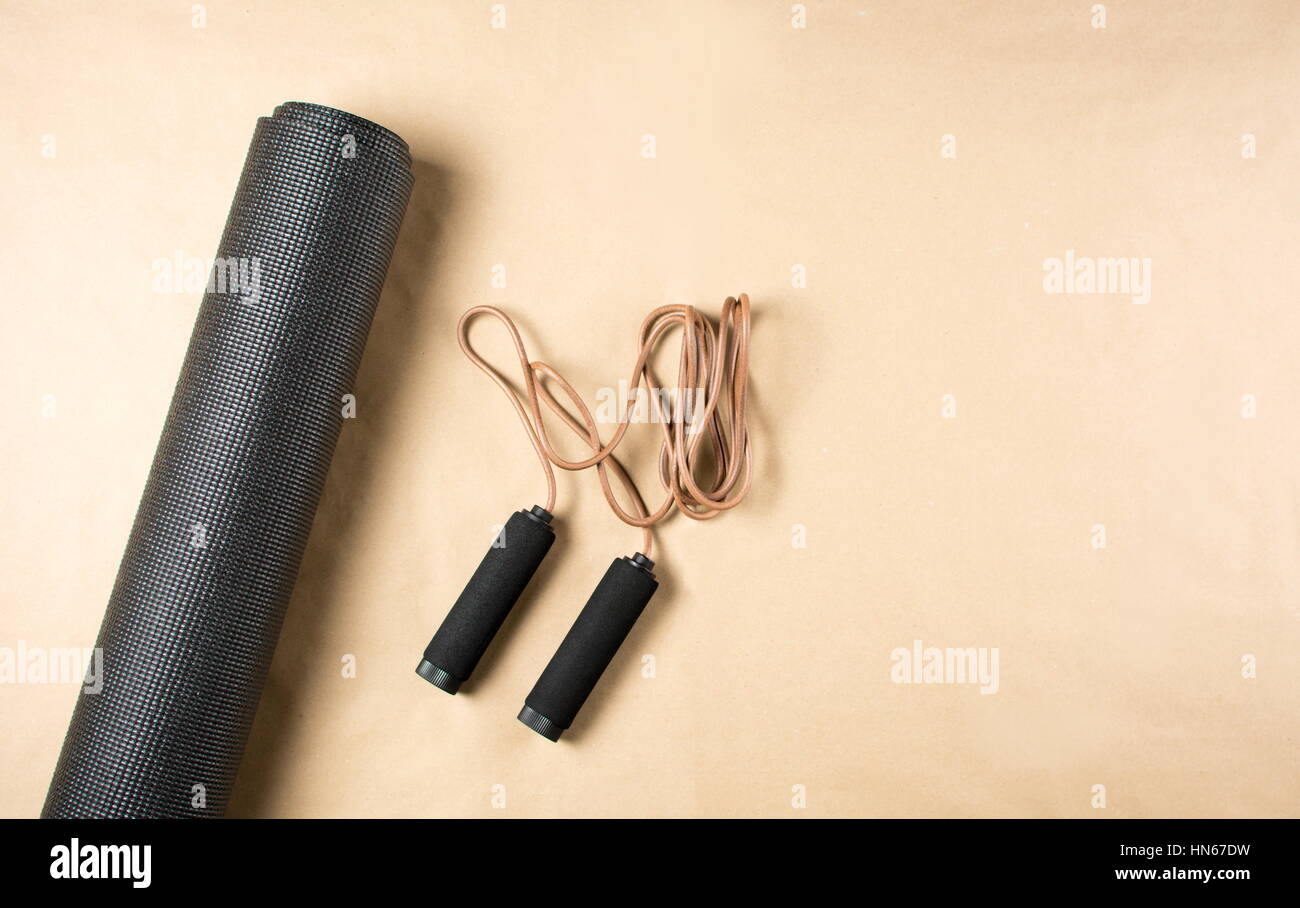 Black yoga mat and leather jumping rope Stock Photo - Alamy