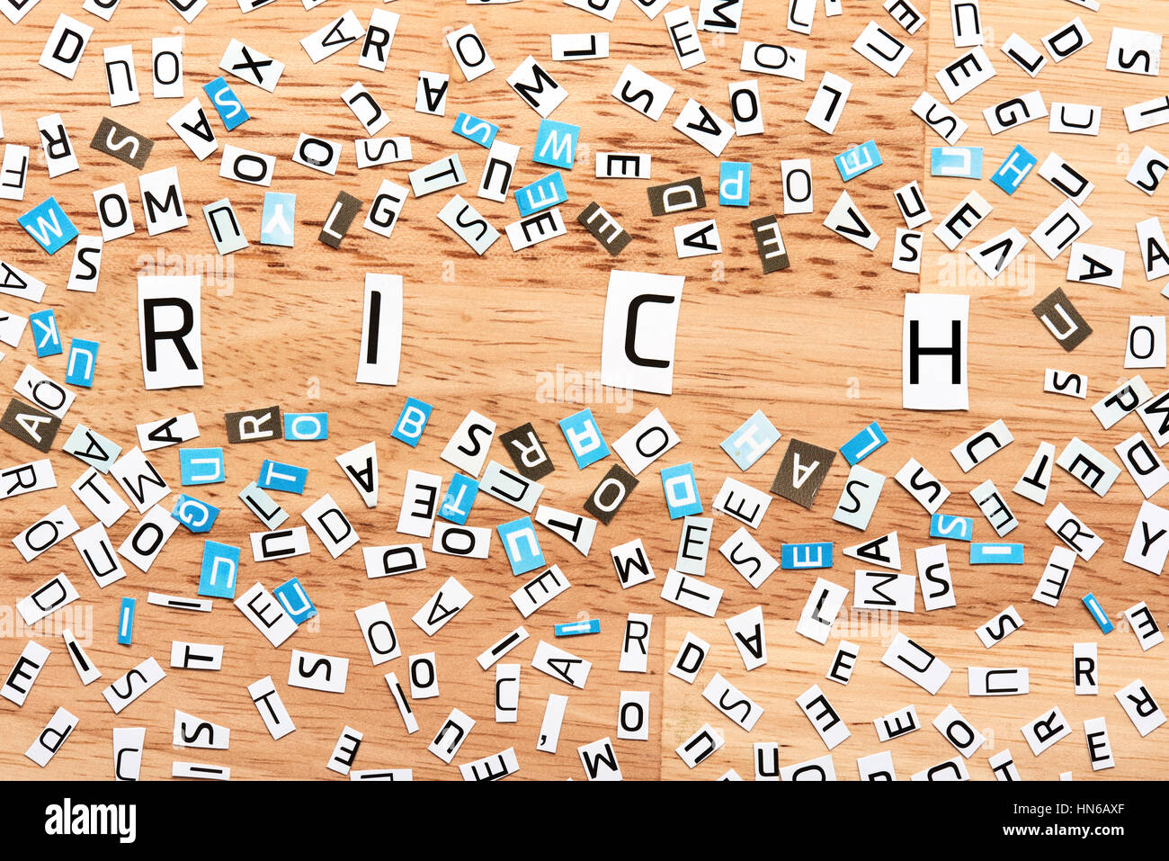 Rich word from cut out letters on wooden table Stock Photo - Alamy