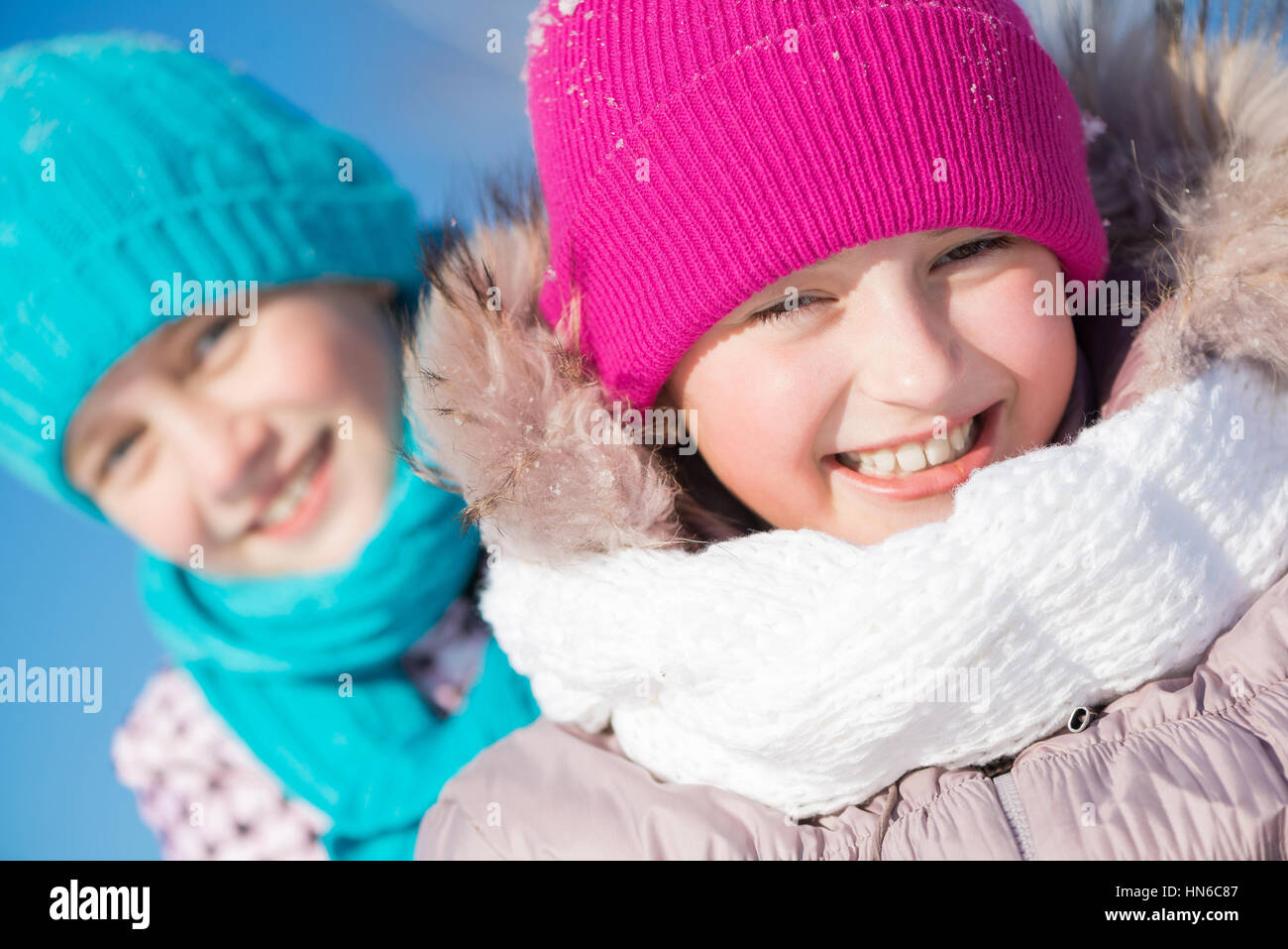 Two cute girls riding sled and having fun Stock Photo - Alamy