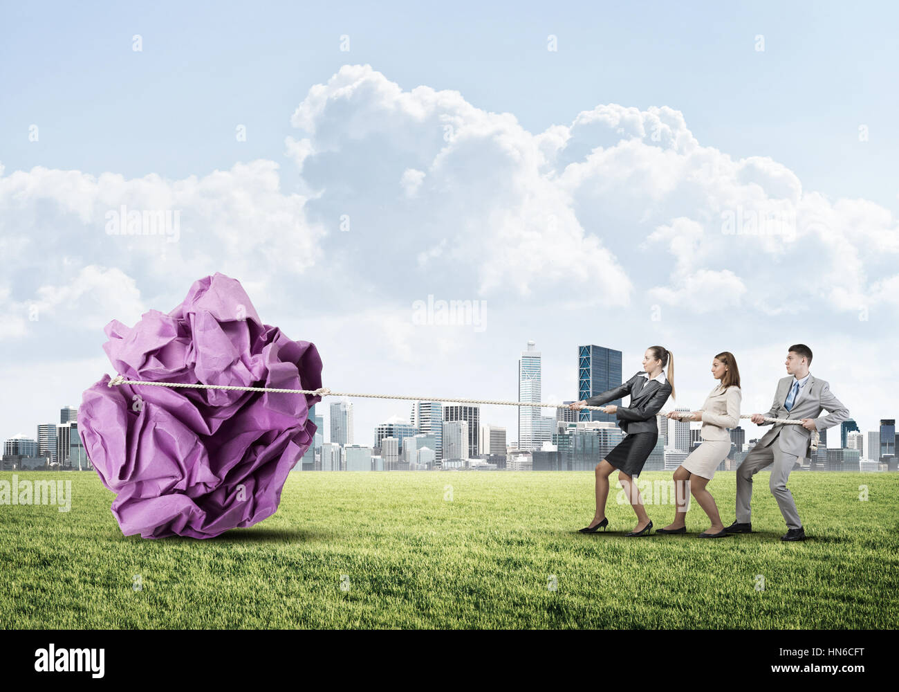 Office employees pulling together big crumpled paper ball Stock Photo ...