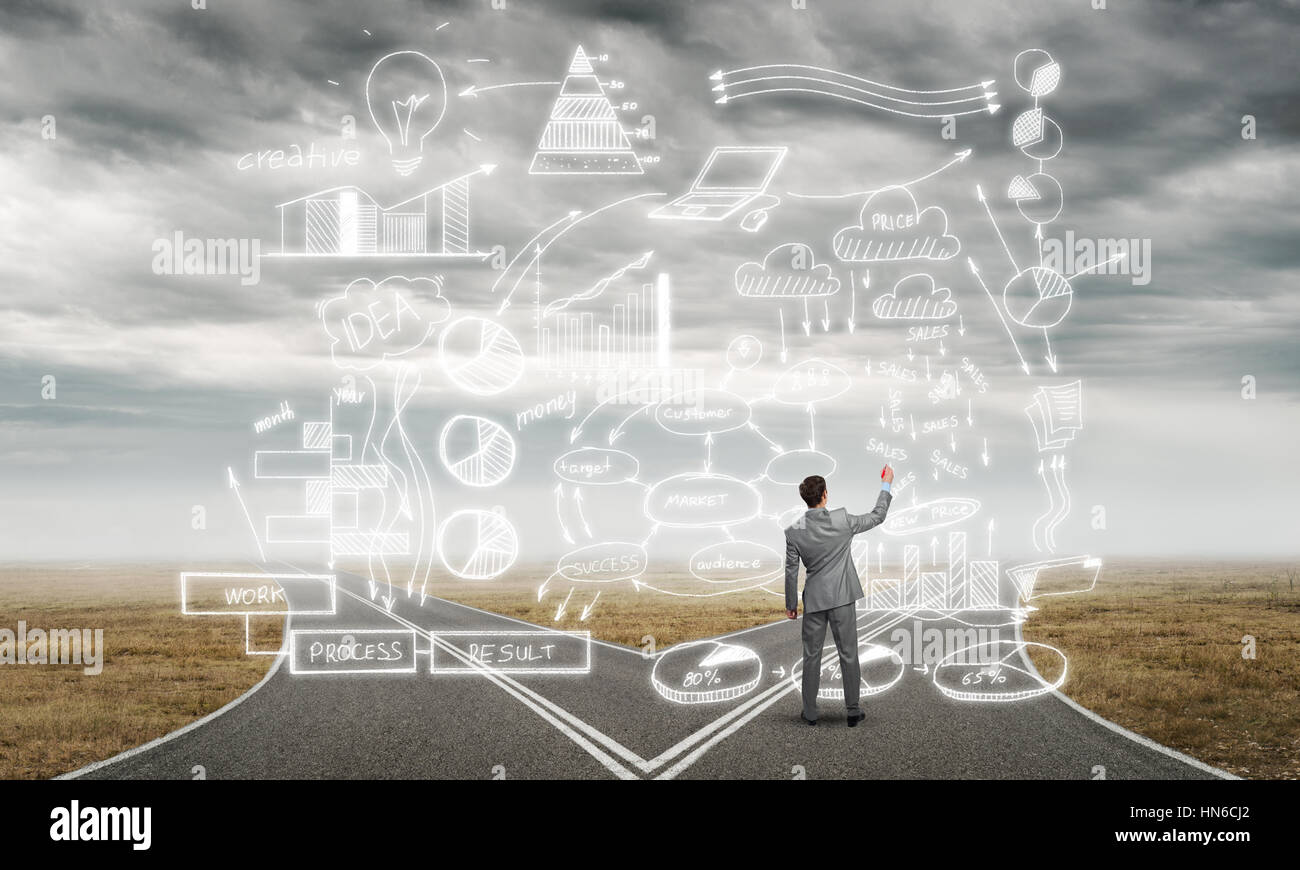 Young businessman on crossroads drawing strategy plan on screen Stock ...