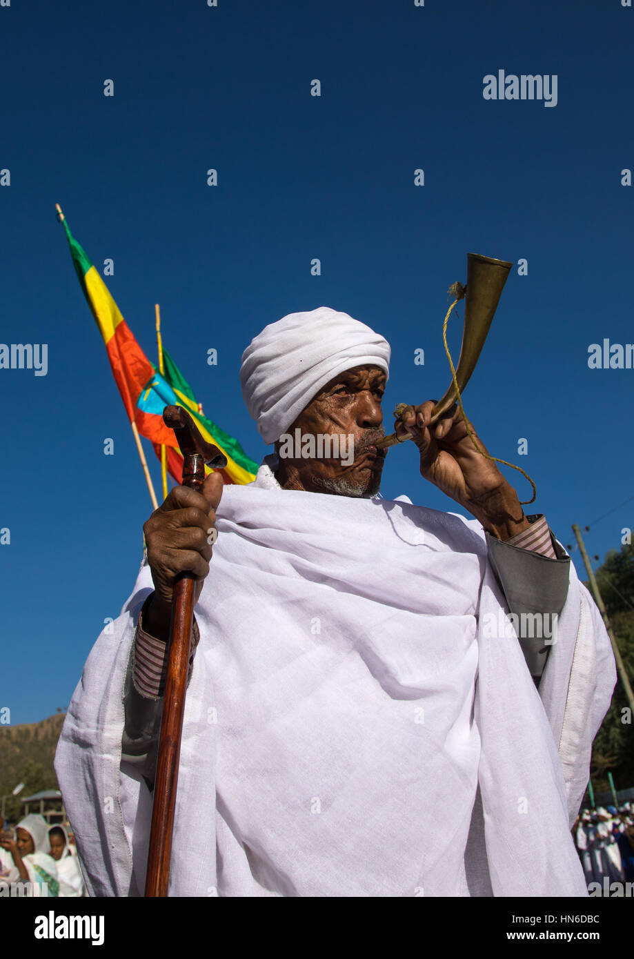 Ethiopian orthodox priest blowing in a horn during the colorful Timkat ...
