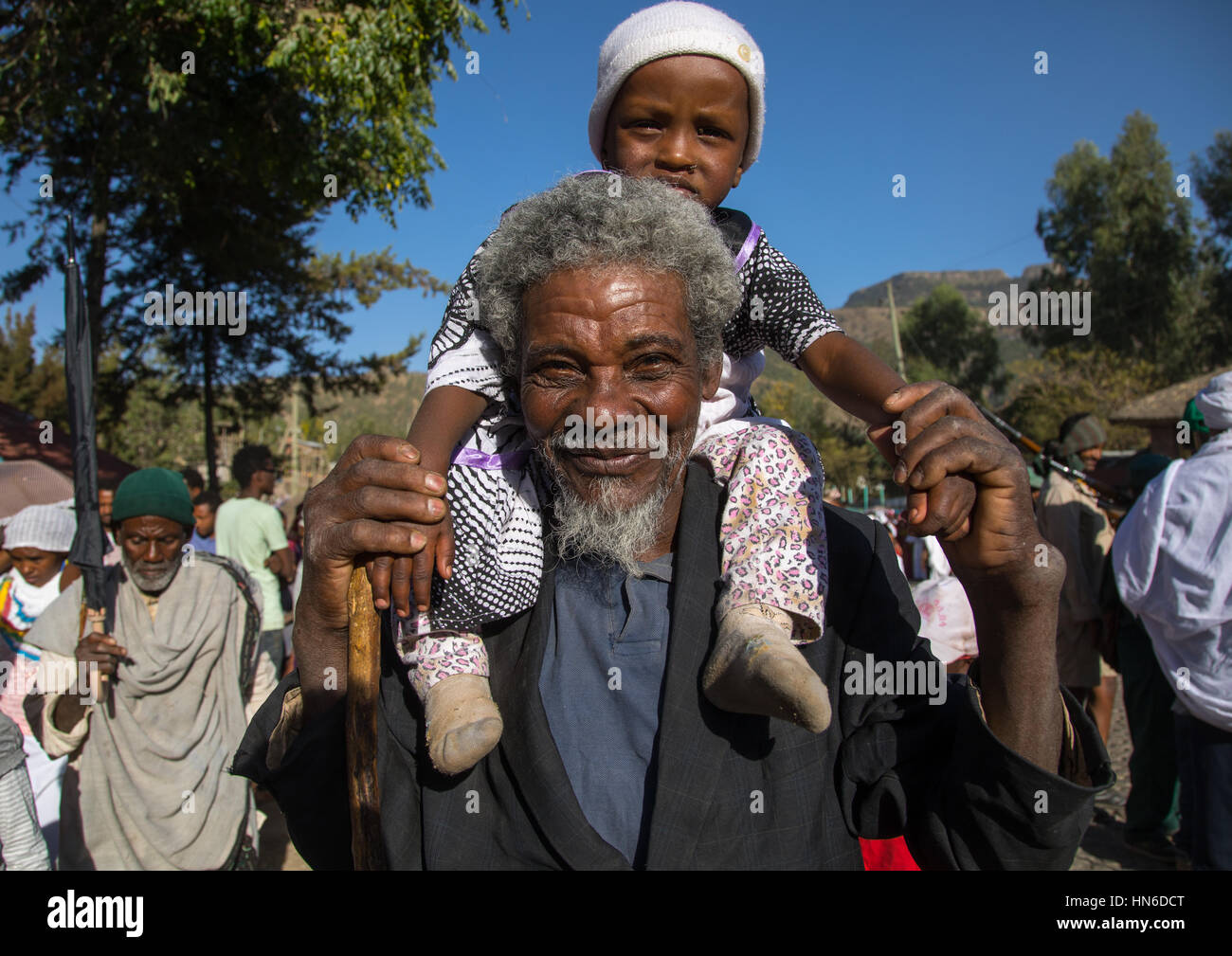 Ethiopian father carrying his son on his back during Timkat epiphany ...