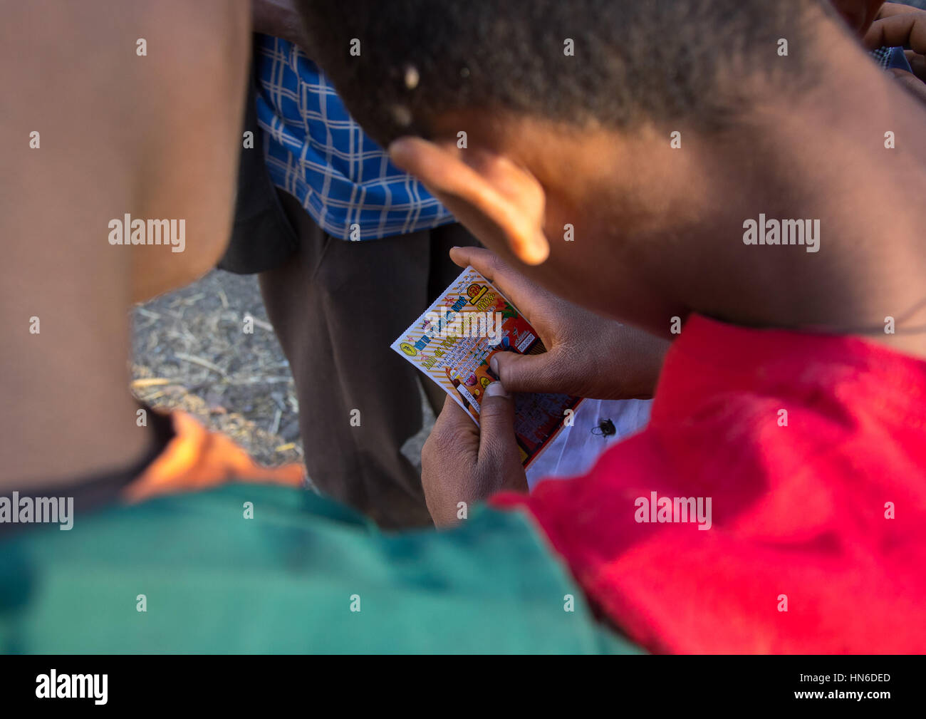 Ethiopian child playing a scratch-off lottery, Amhara region, Lalibela ...