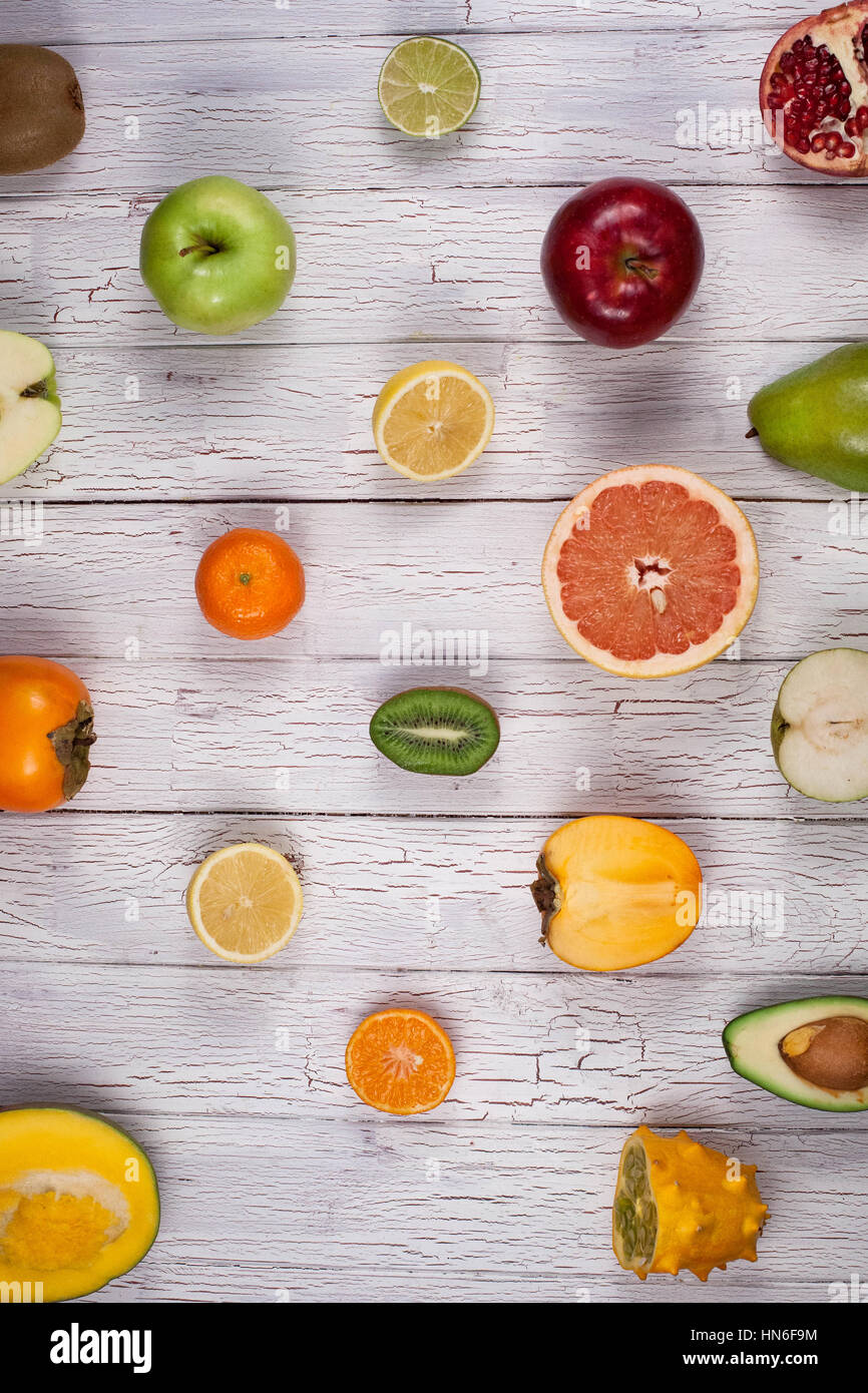 Coloured juicy fruits in a checkerboard pattern place on a light wooden ...