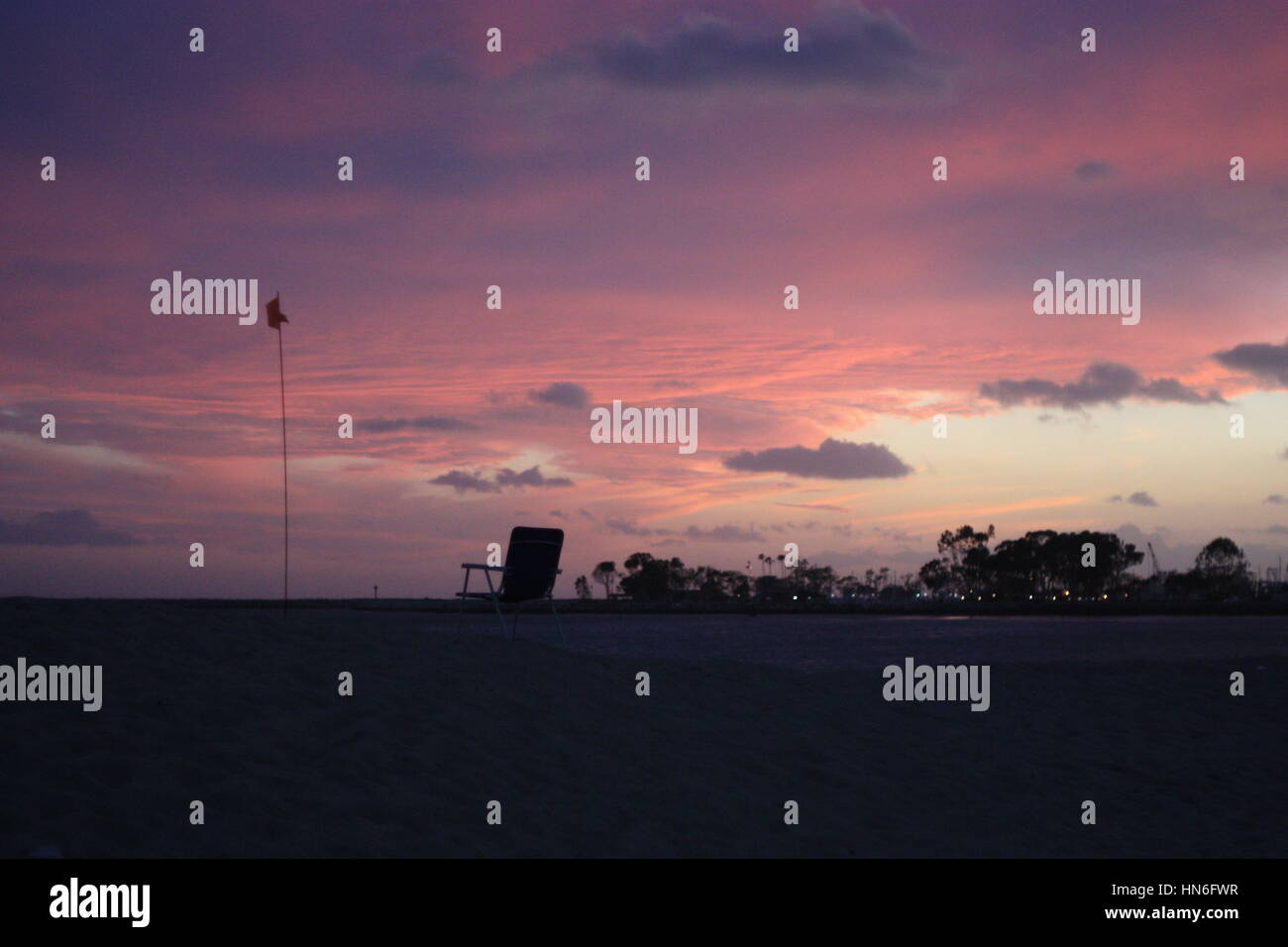 sunset on a beach where the tired person can relax on a beach chair ...