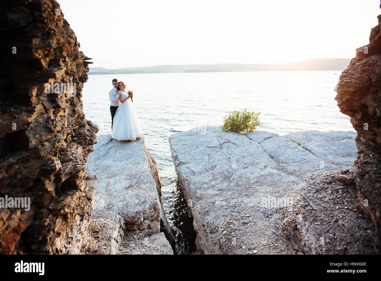 beautiful gorgeous blonde bride and stylish groom on rocks Stock Photo ...