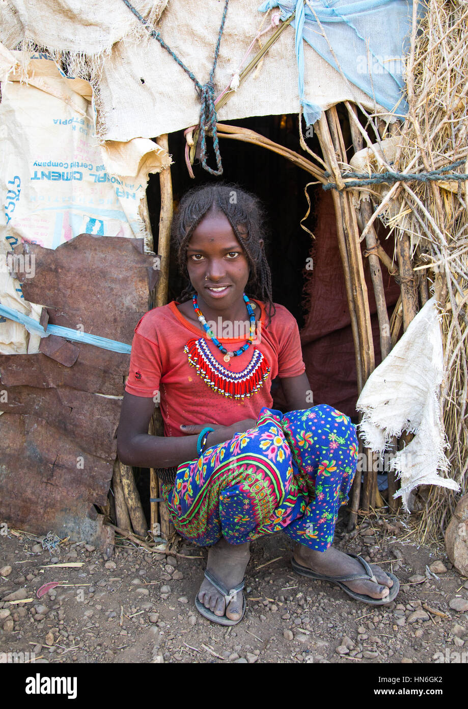 Portrait Of An Afar Tribe Girl With Braided Hair In Front Of Her Hut