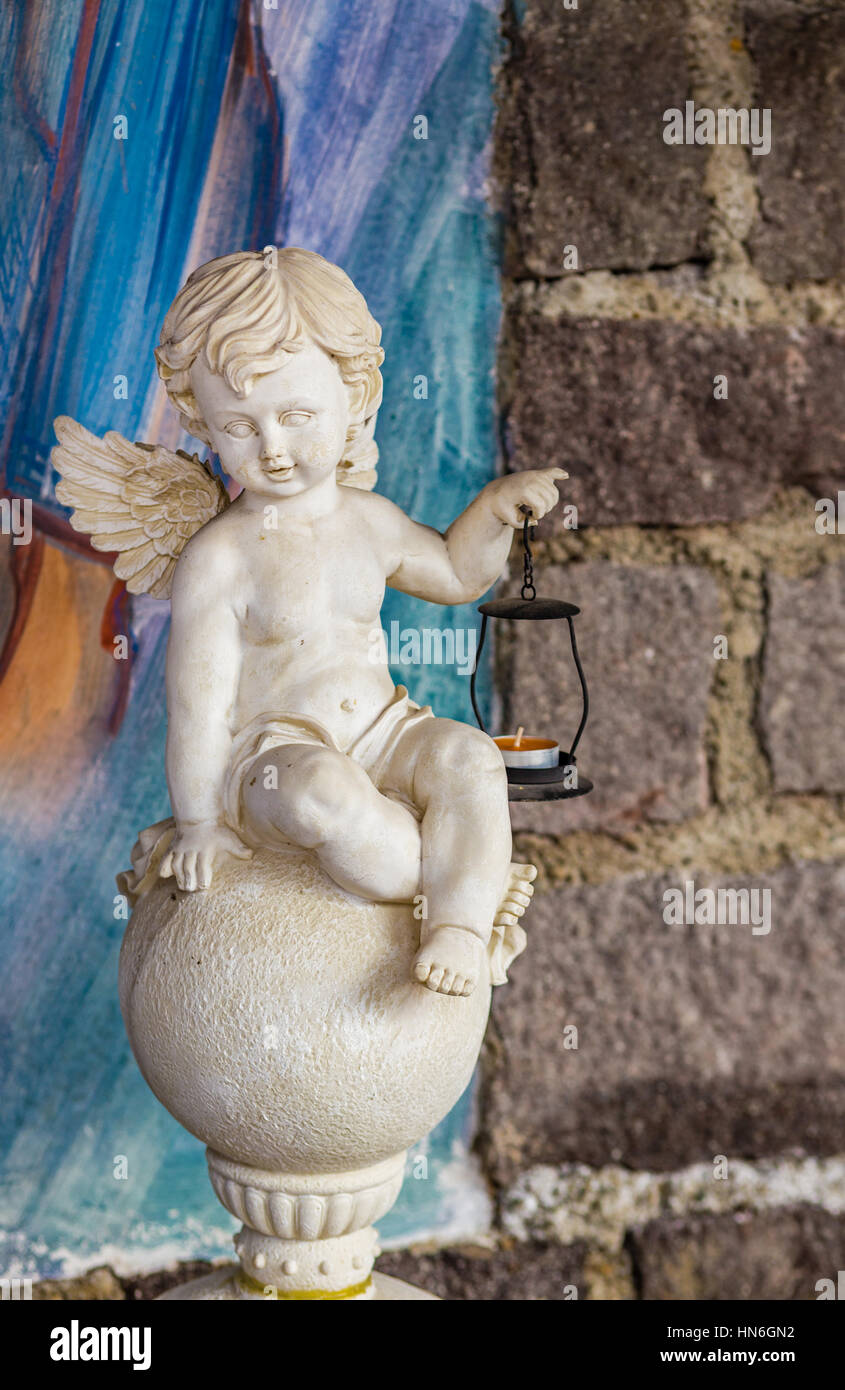statue of angel holding a lantern with the candle Stock Photo - Alamy