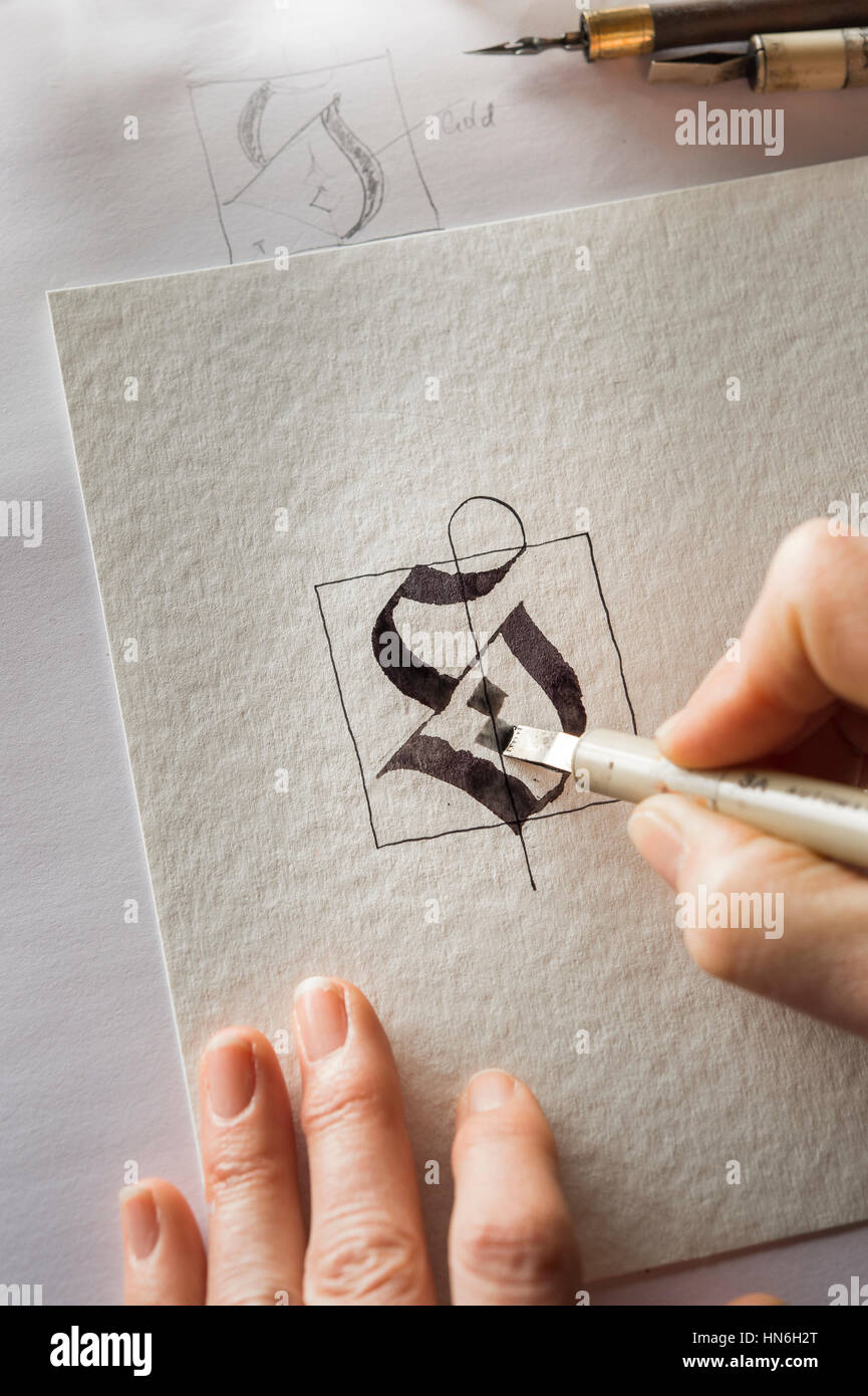 Calligraphy studio, hand writes with automatic pen, letter S on torchon ...