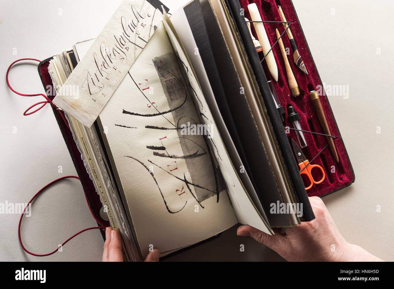 Calligraphy studio, hands holding old compass box with calligraphic ...