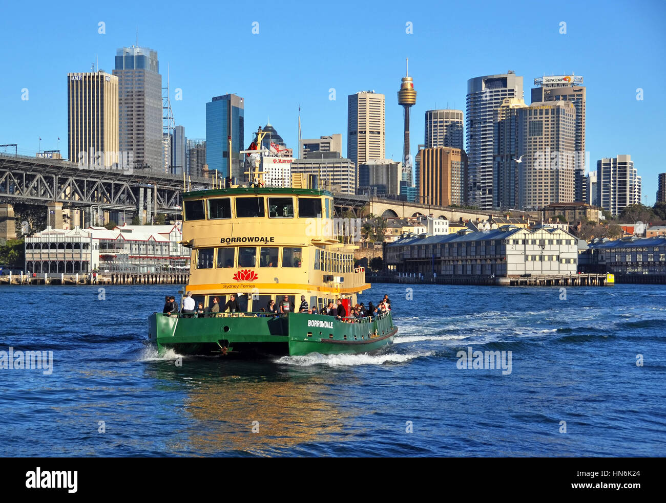 One of Sydney's famous green and yellow ferry boats crosses the harbour ...