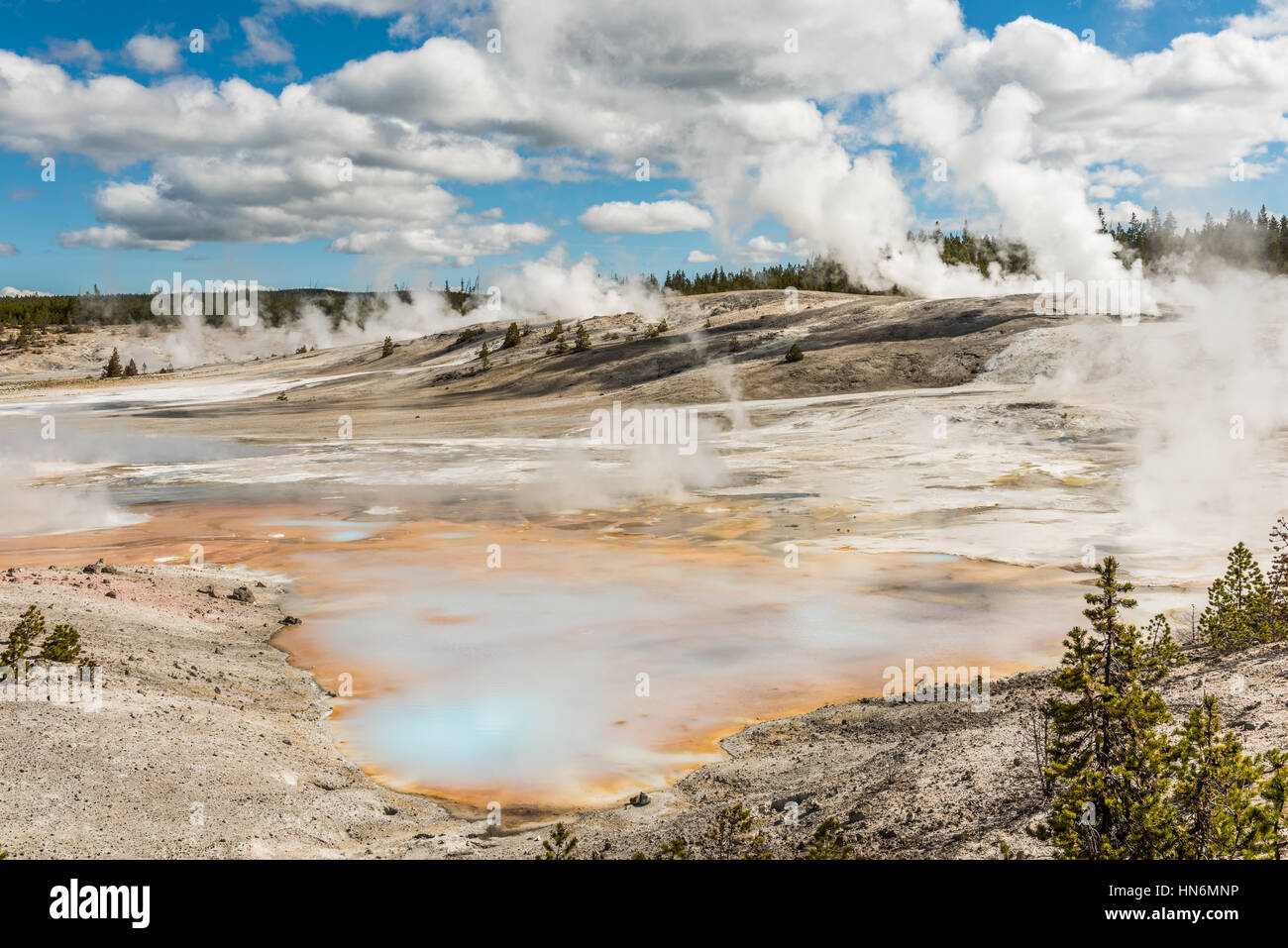 Hot spring pools with blue and orange colors and steam geysers in ...