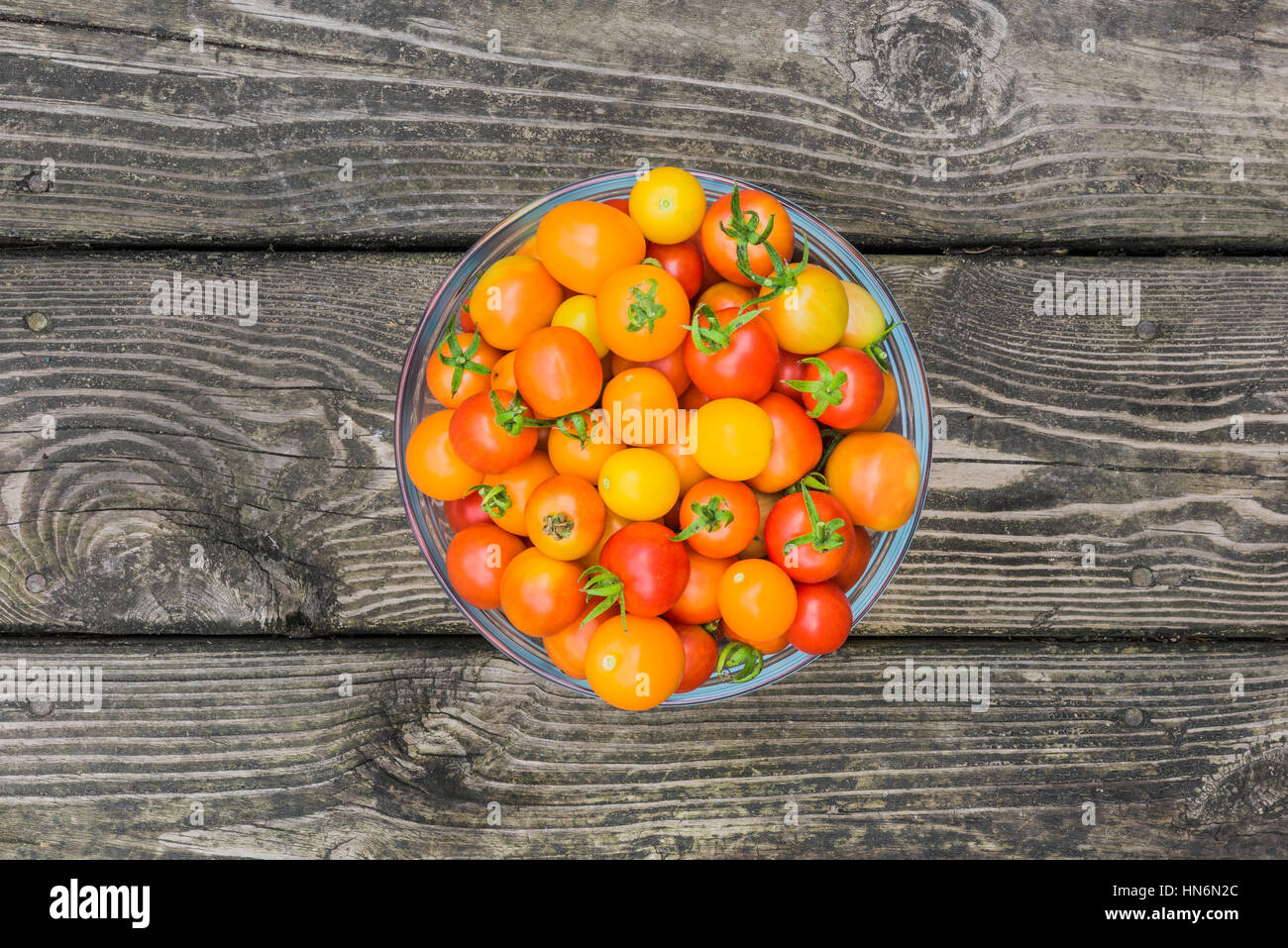 Flat view from above of red and yellow cherry tomatoes in glass bowl ...