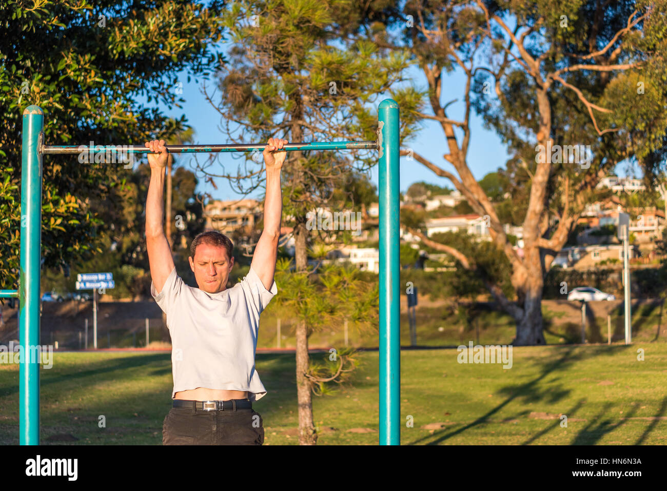 Fit muscular man doing pull ups in outdoor park Stock Photo - Alamy