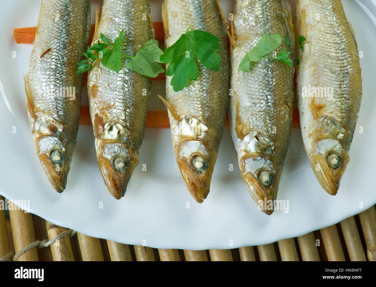 baked smelt served with roasted carrots Stock Photo - Alamy