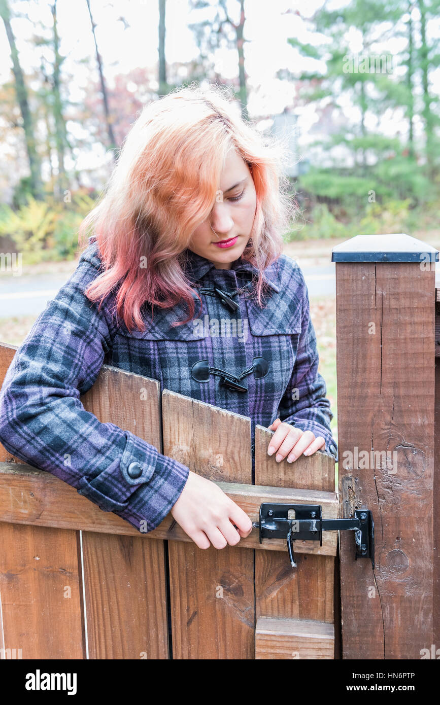 Woman closing padlock on gate hi-res stock photography and images - Alamy
