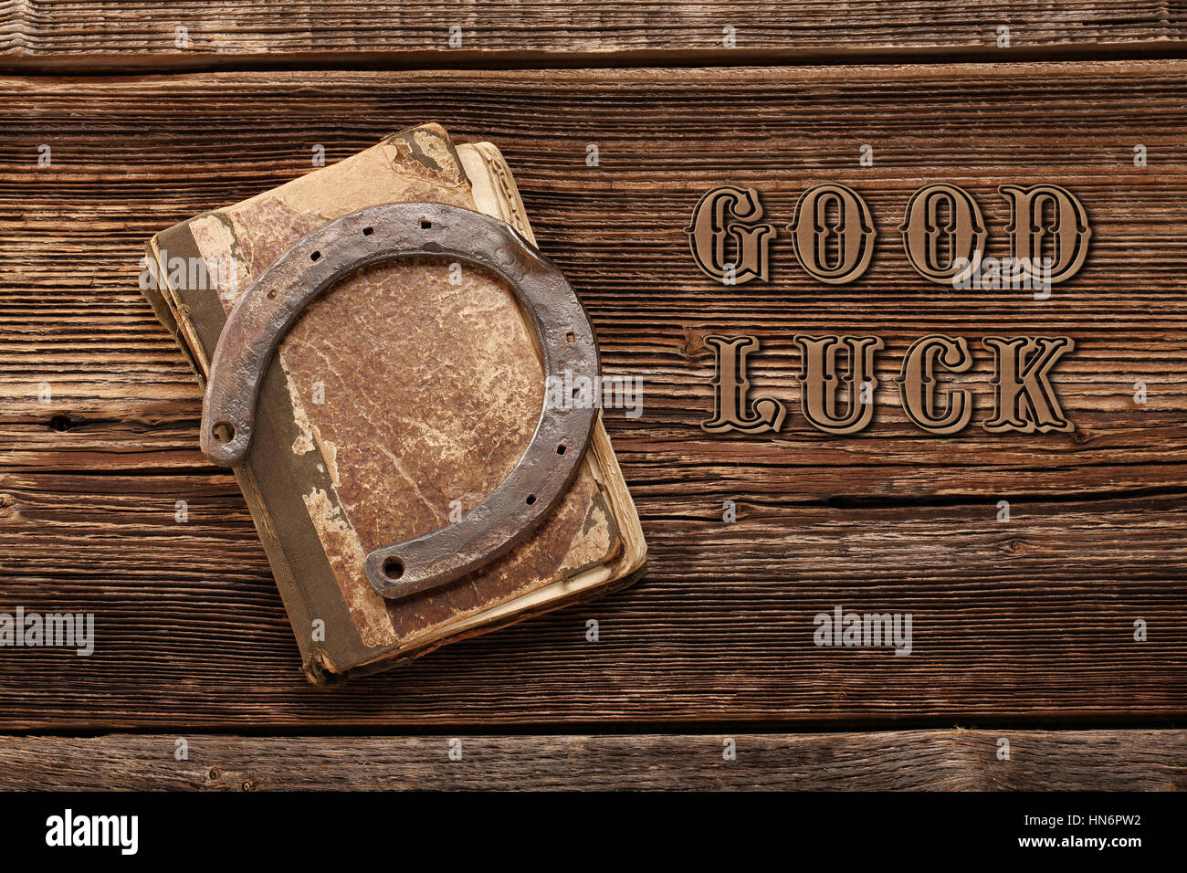 Old rusty horseshoe and book on wooden background with good luck ...