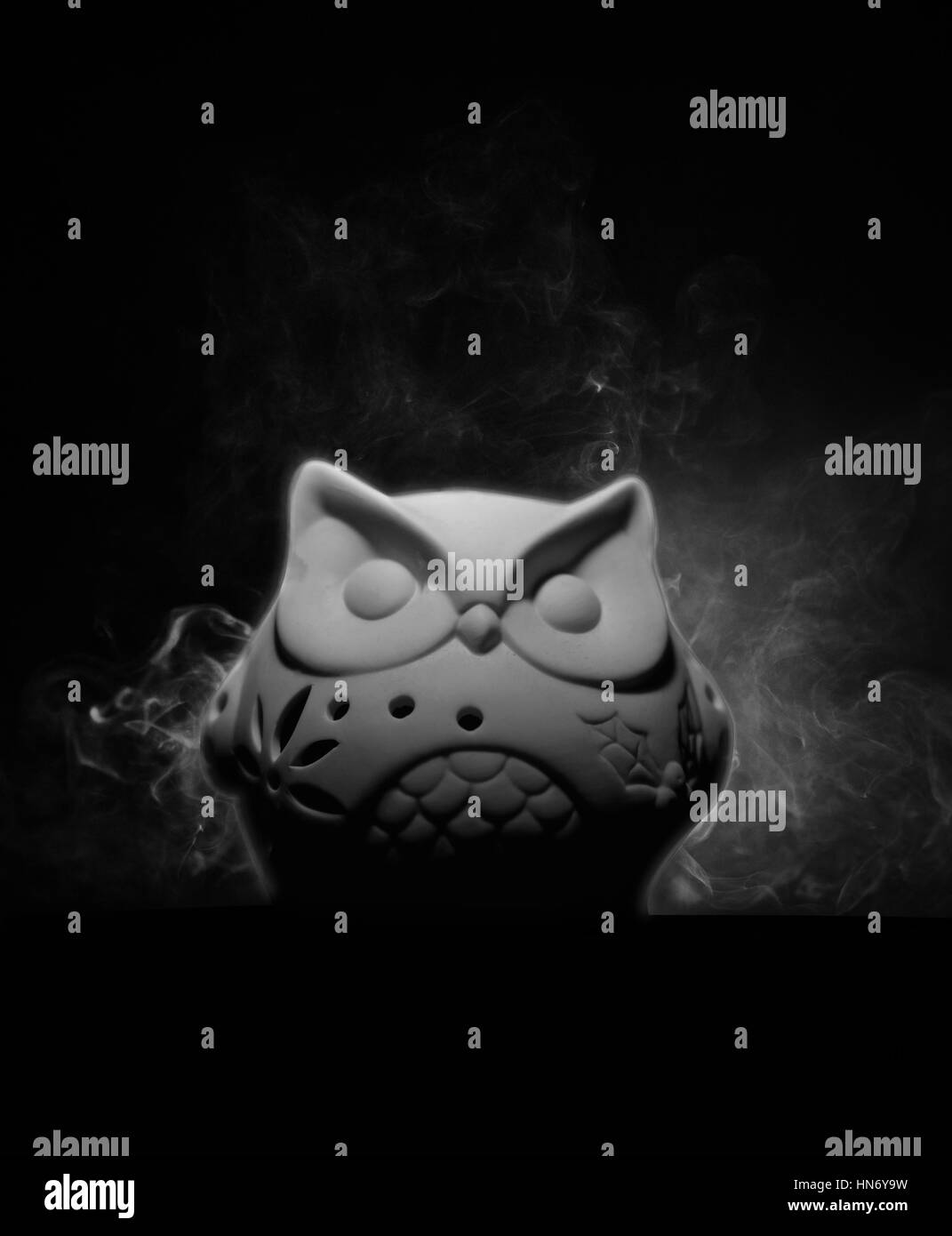 an ceramic owl with some nice smoke behind it Stock Photo - Alamy