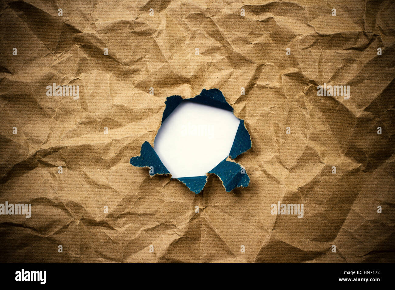Torn hole in brown crumpled wrapping paper Stock Photo - Alamy