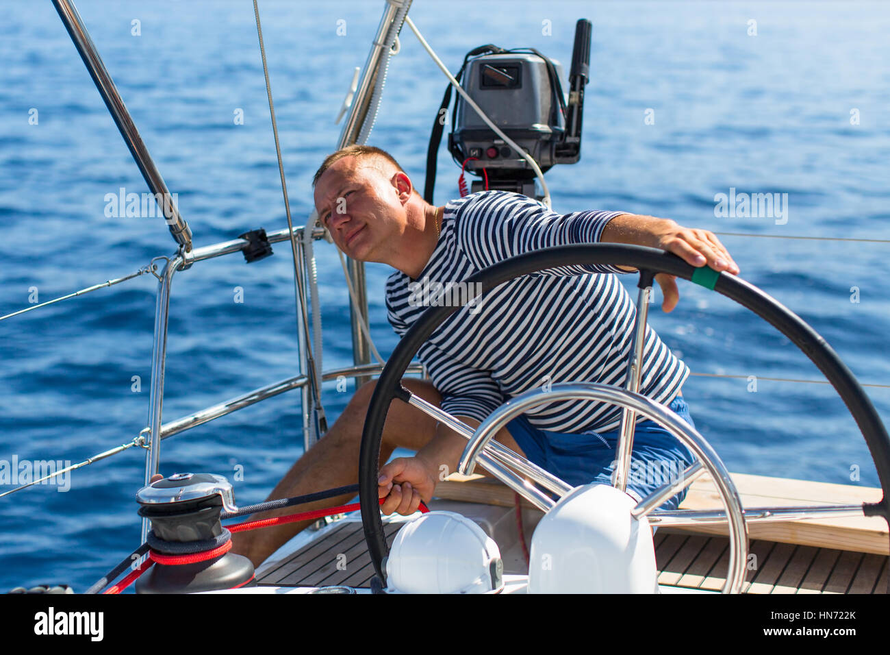 Man manages a sailing yacht during a race at sea Stock Photo - Alamy