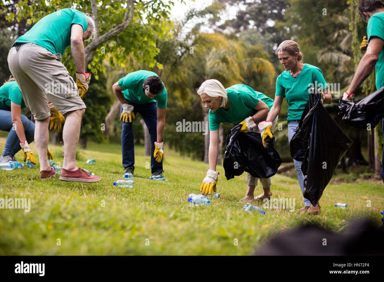 Team of volunteers picking up litter in park Stock Photo - Alamy
