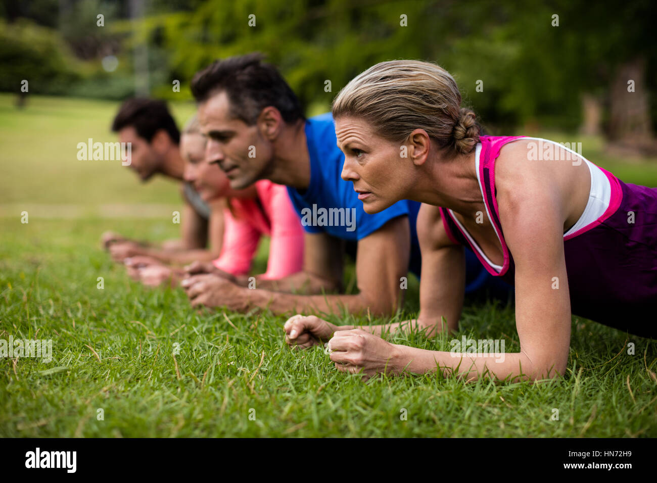 Group of people performing stretching exercise in park Stock Photo - Alamy