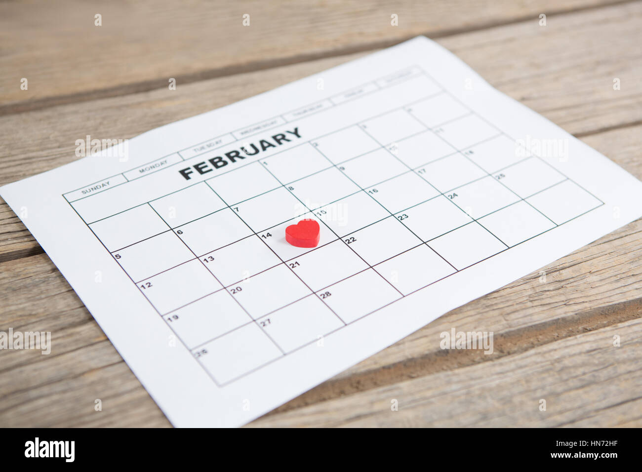 Red heart shape placed on 14th february date of the calendar on wooden ...