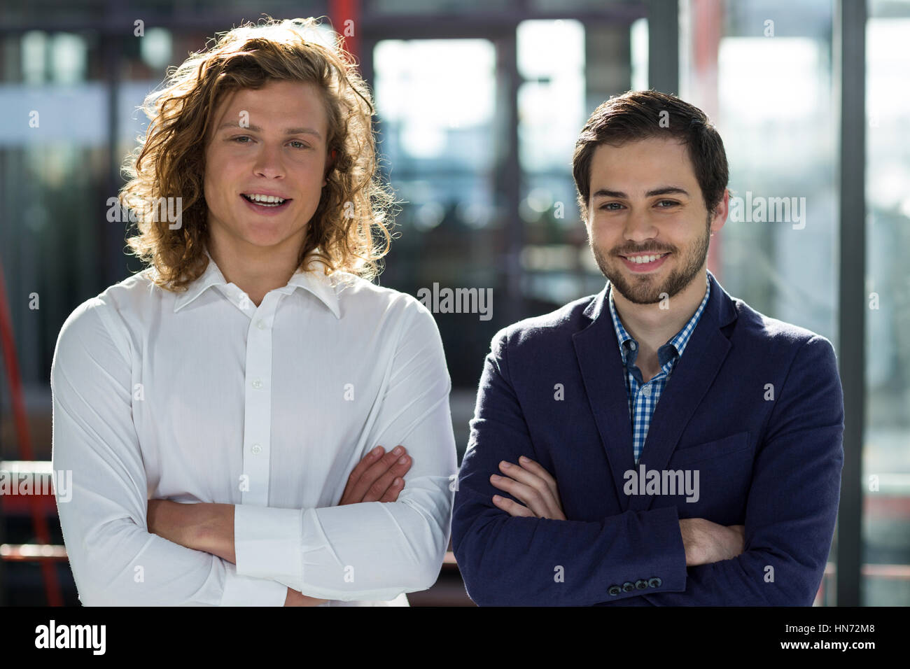 Two male business executives standing with arms crossed in office Stock ...
