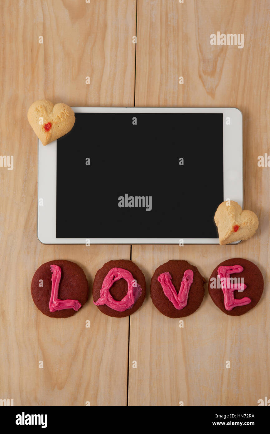 Conceptual image of digital tablet and cookies with love message on ...