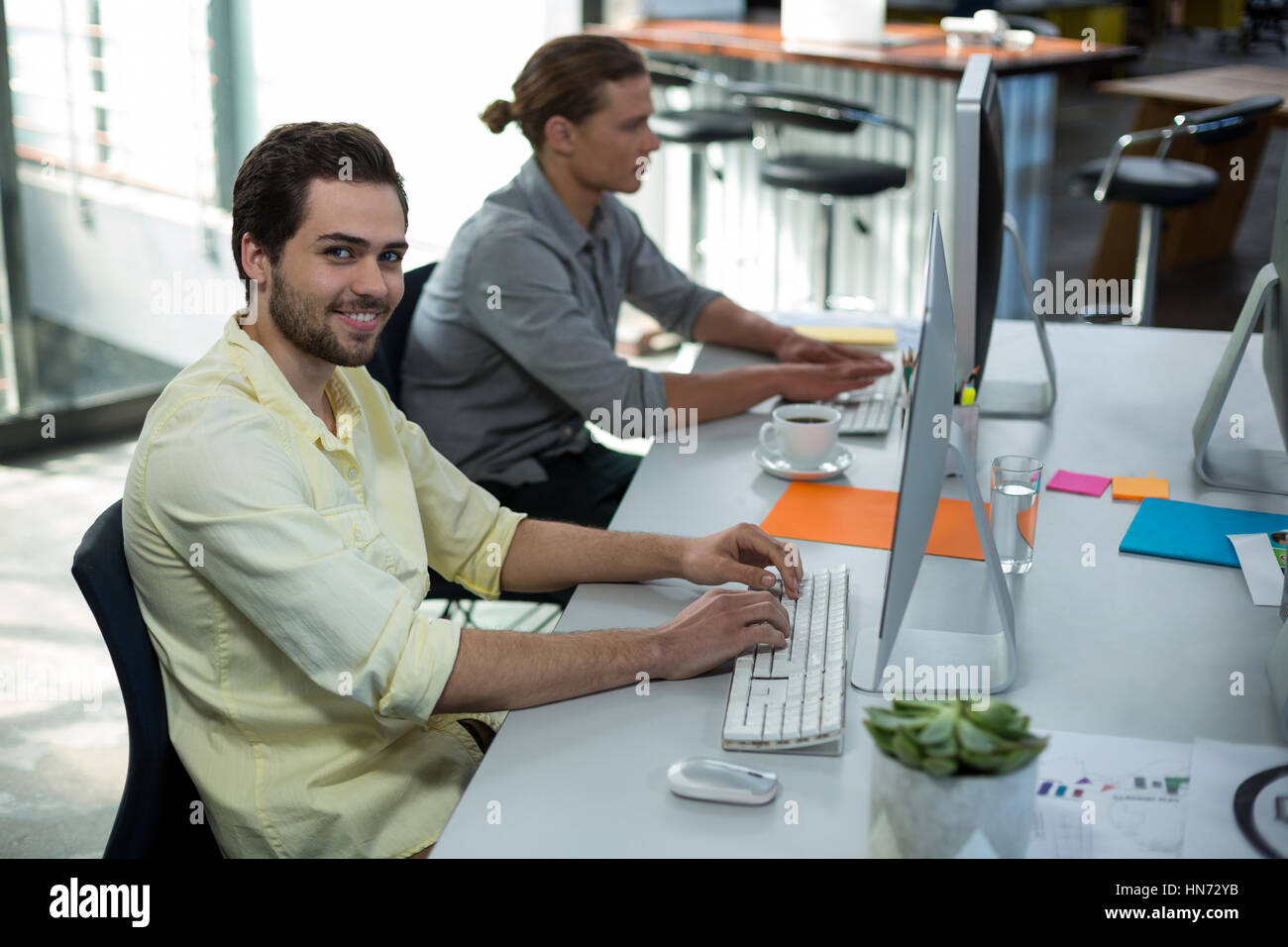 Portrait of male graphic designer working on personal computer in ...
