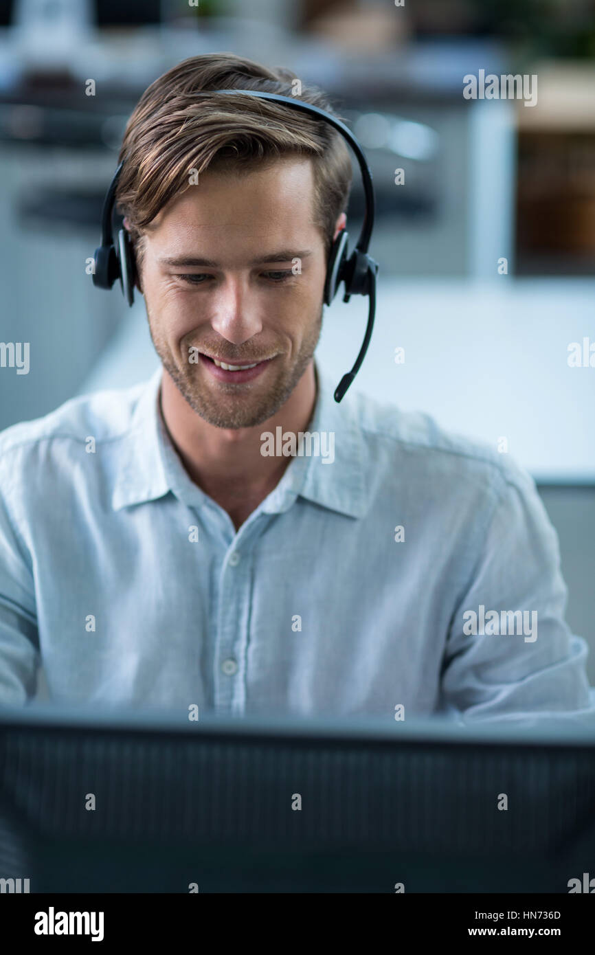 Smiling business executive with headsets in office Stock Photo - Alamy