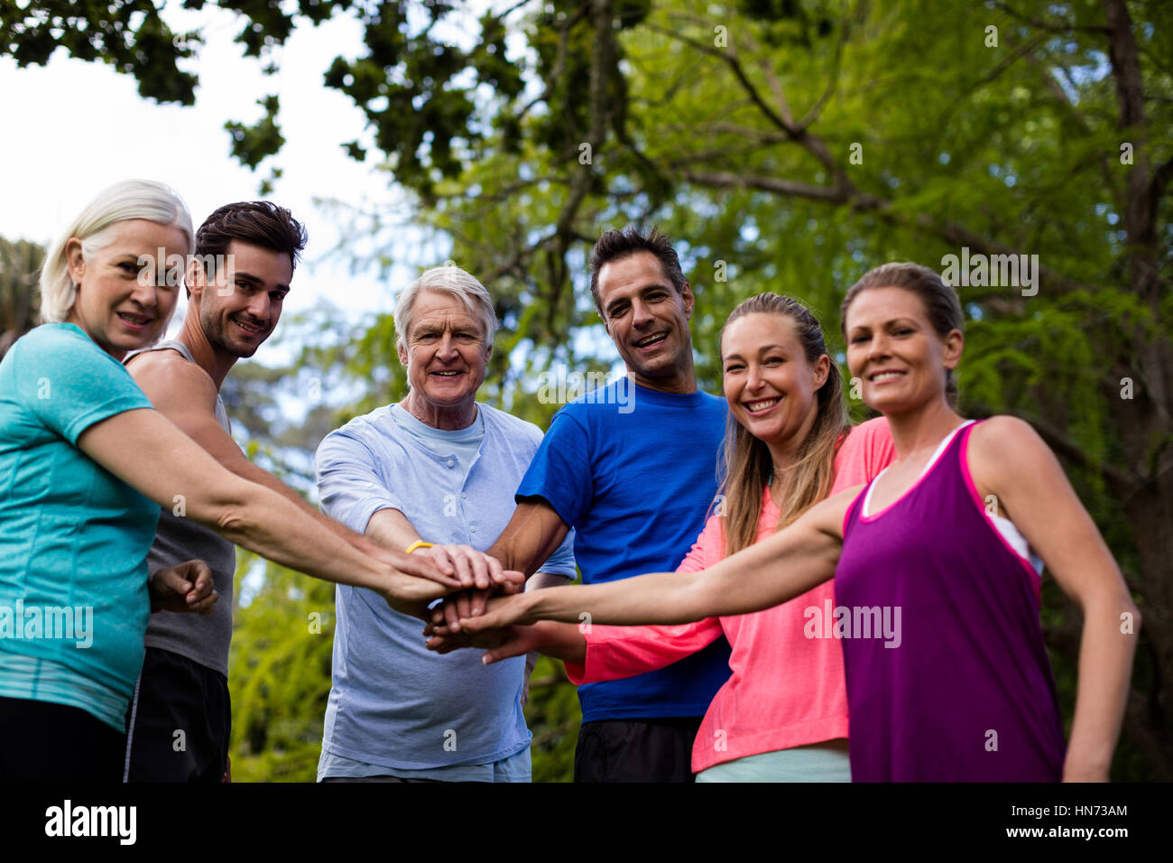 Group of people doing a hand stack in park Stock Photo - Alamy