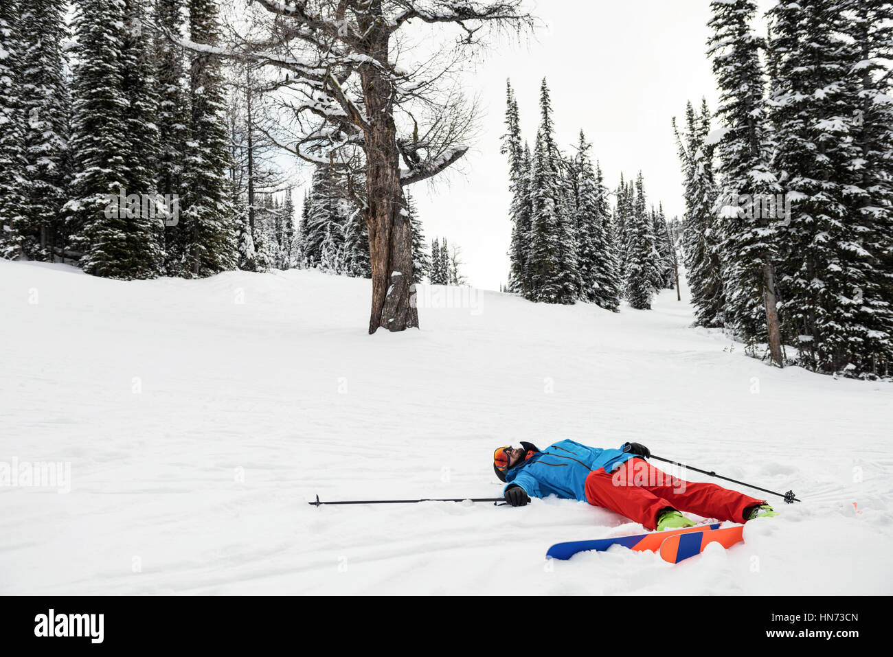 Skier lying with ski on snow covered mountains Stock Photo - Alamy
