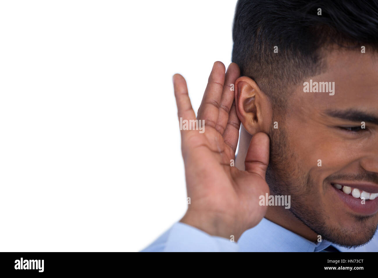 Businessman listening with hand on ear against white background Stock ...