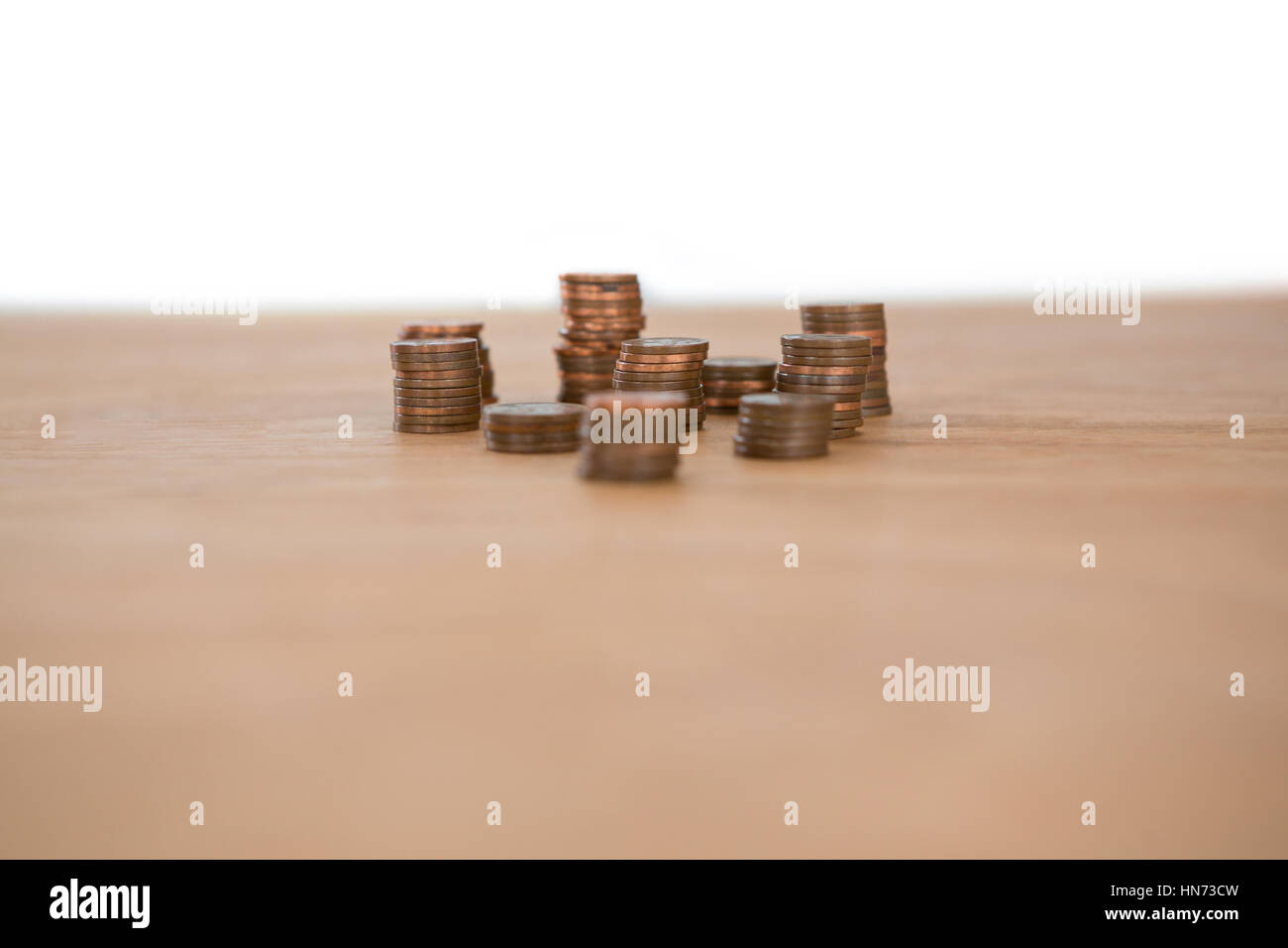 Stack of coins on table against white background Stock Photo - Alamy