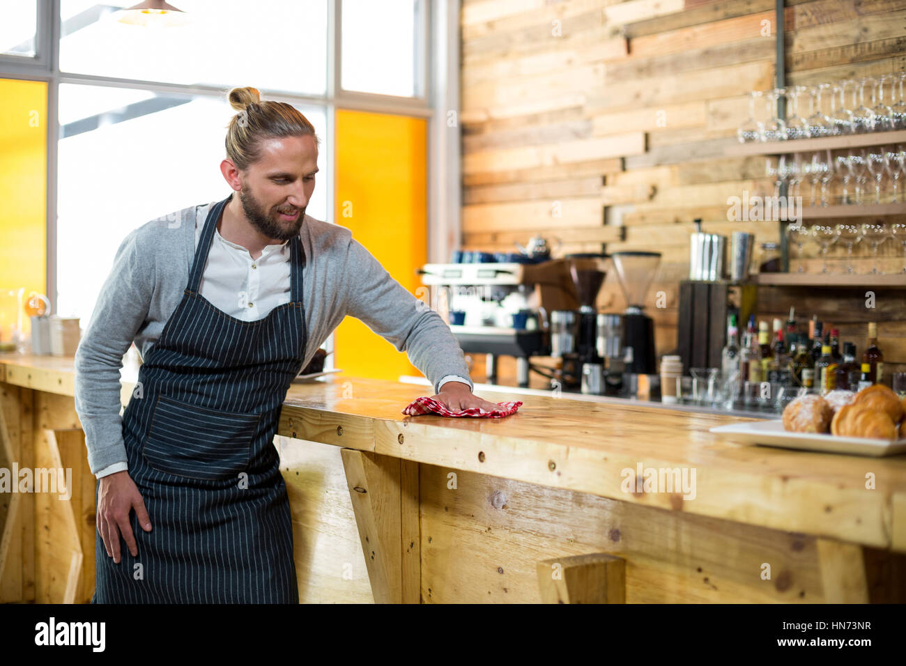 Attentive waiter wiping counter with napkin in cafÃƒÂ© Stock Photo - Alamy