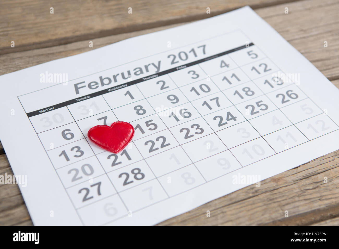 Red heart shape placed on 14th february date of the calendar on wooden ...