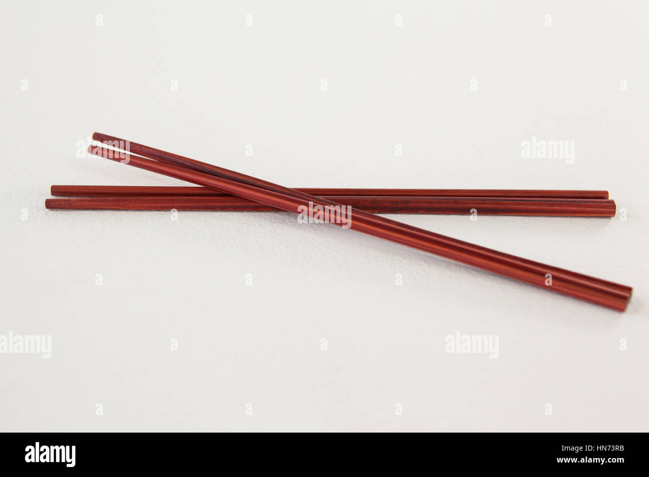 Pair of two red chopsticks against white background Stock Photo - Alamy