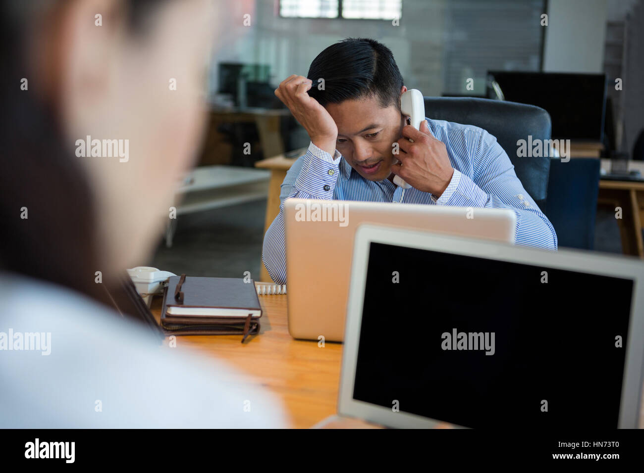 Frustrated business executive talking on telephone in office Stock ...