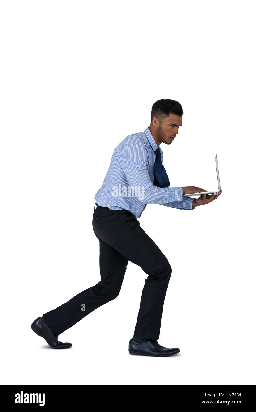 Businessman running while using laptop against white background Stock ...