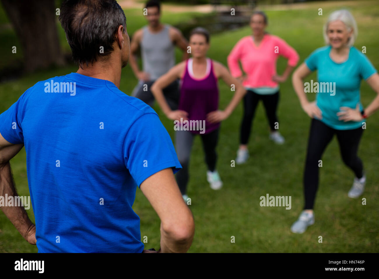 Group of people performing stretching exercise in park Stock Photo - Alamy