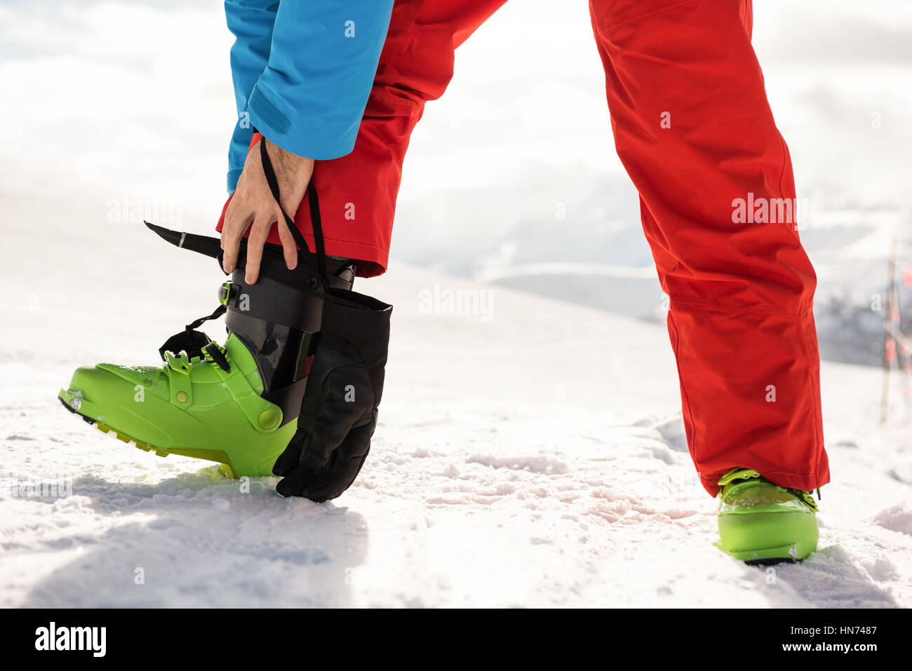 Low section of skier tying his boot strap Stock Photo - Alamy