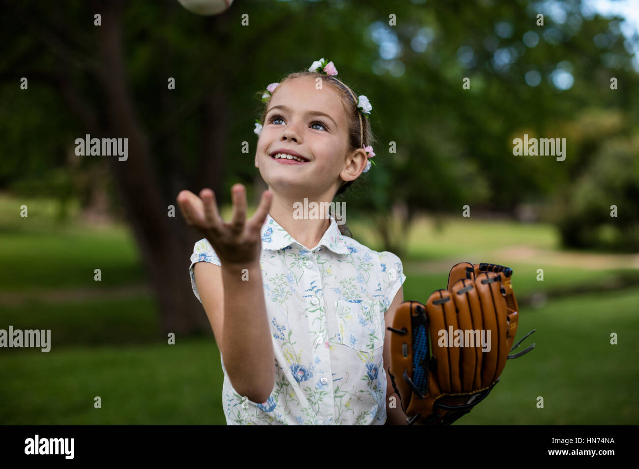 Portrait of cute girl with baseball in park Stock Photo - Alamy