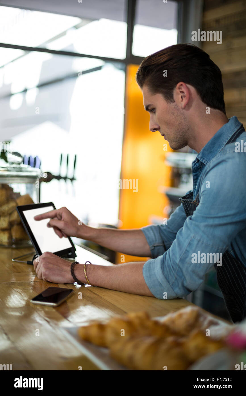 Waiter standing at counter using digital tablet in cafÃƒÂ© Stock Photo ...