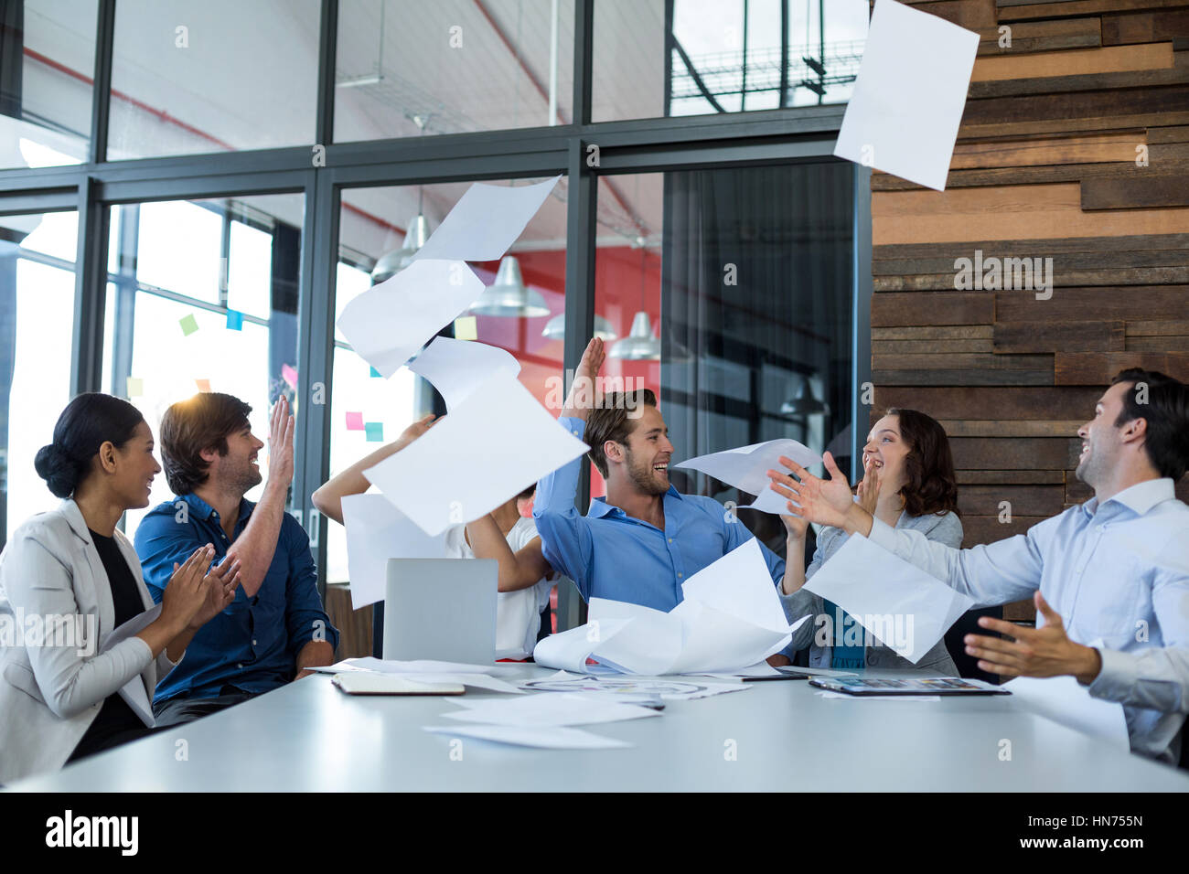 Team of graphic designers throwing documents up in air at office Stock ...
