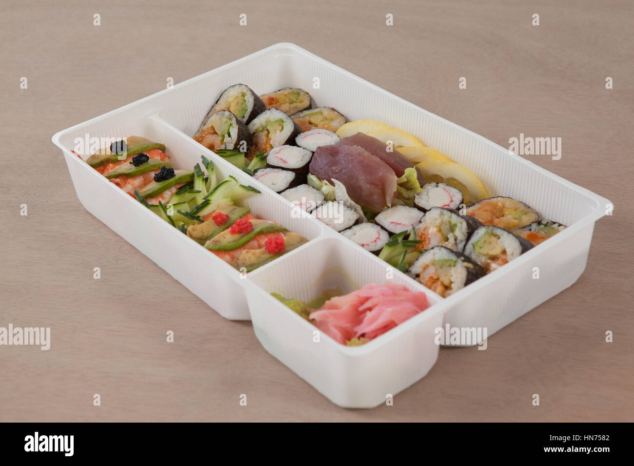 Set of assorted sushi kept in a white box on wooden table Stock Photo ...